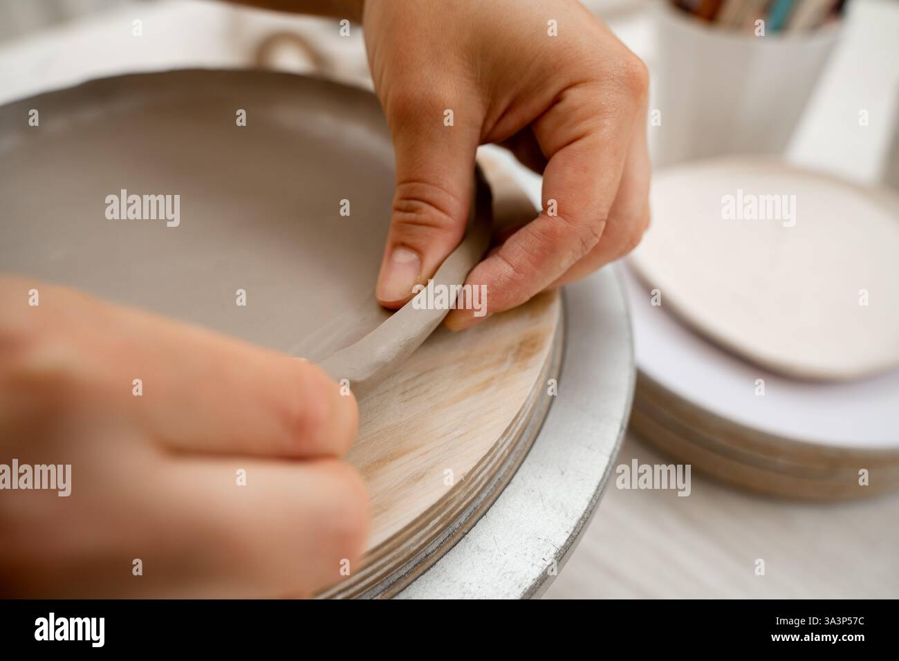 Creating ceramic products from flat sheets of clay. Using hands to ...