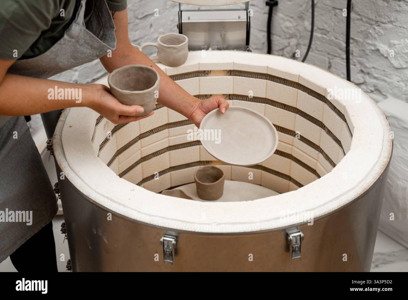 Placing pottery in a muffle furnace to heat it to high temperatures ...