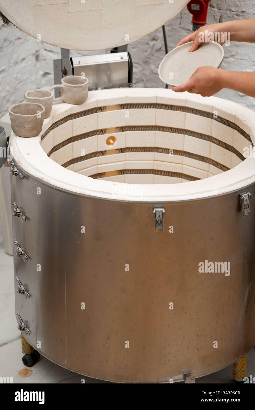 Muffle furnace functioning. Putting ceramic products in a muffle ...