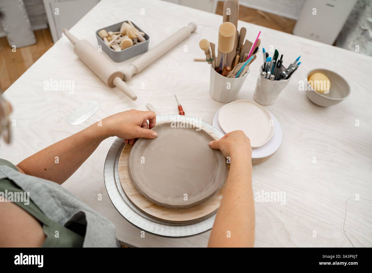 Creating ceramic products from flat sheets of clay. Using hands to ...