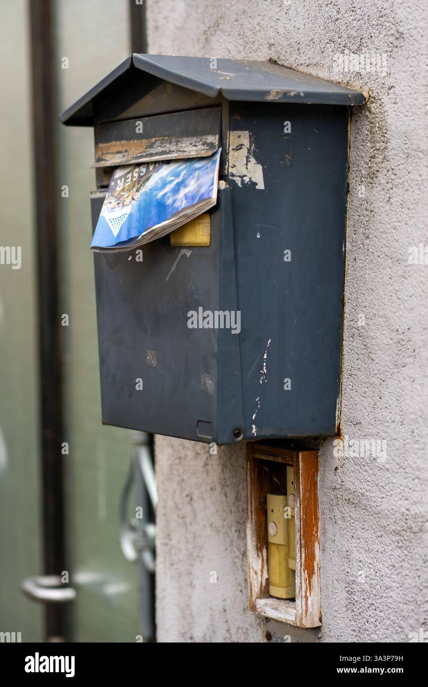 Side view of an old abandoned mailbox with old newspapers and magazines ...