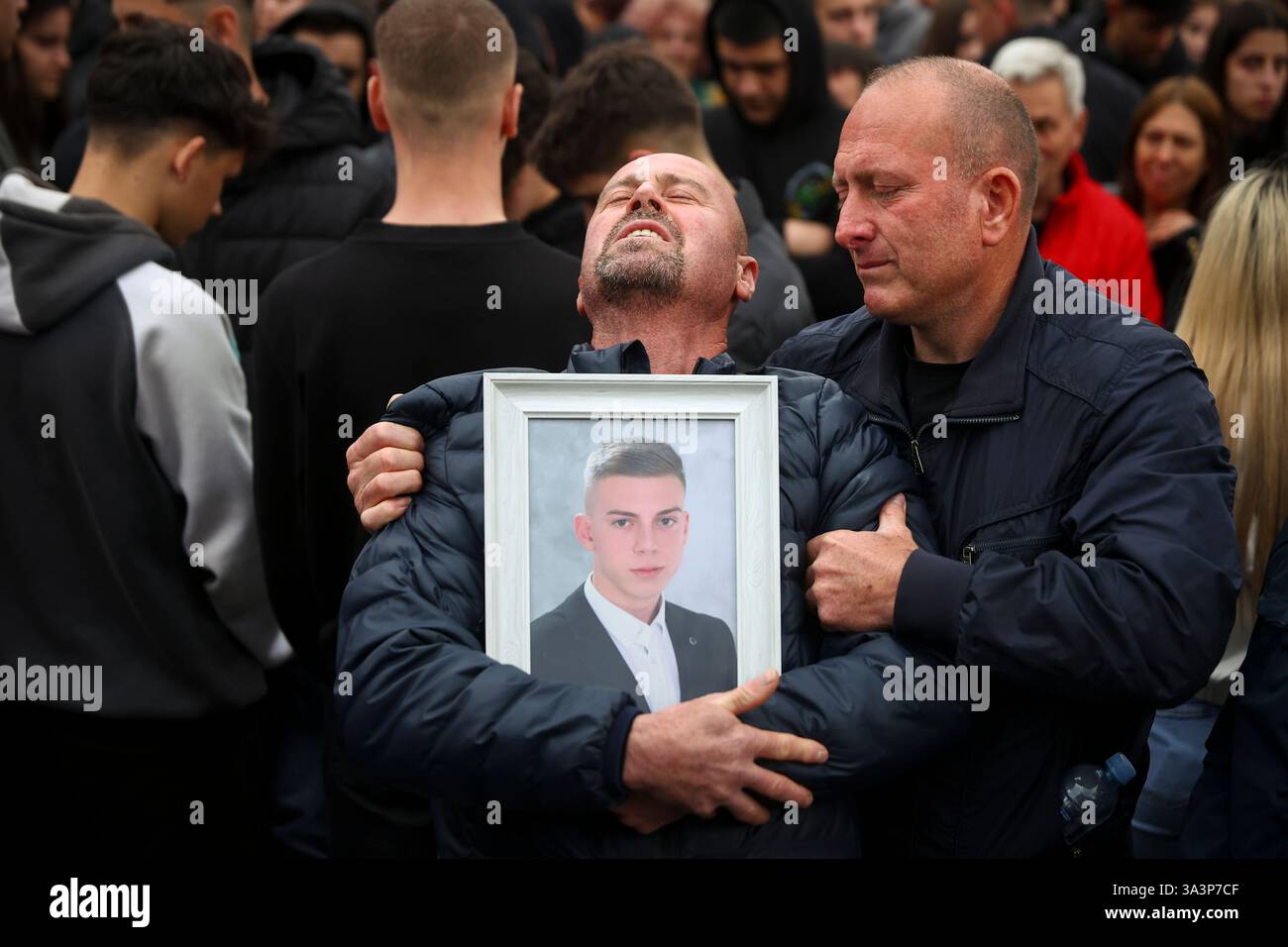 Dragi Stojanov cries holding a photograph of his son Tomche Stojanov ...