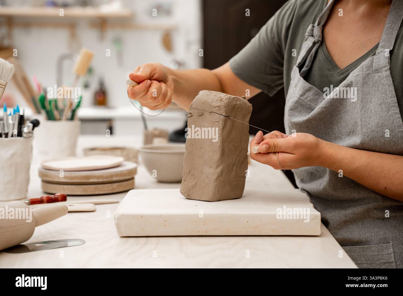 Wire clay cutter to cut clay from a large block. Cutting off the ...