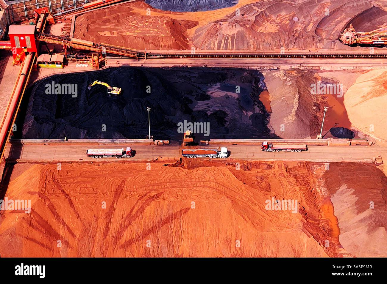Engineering machines work on the dock for imported iron ore in a cargo ...