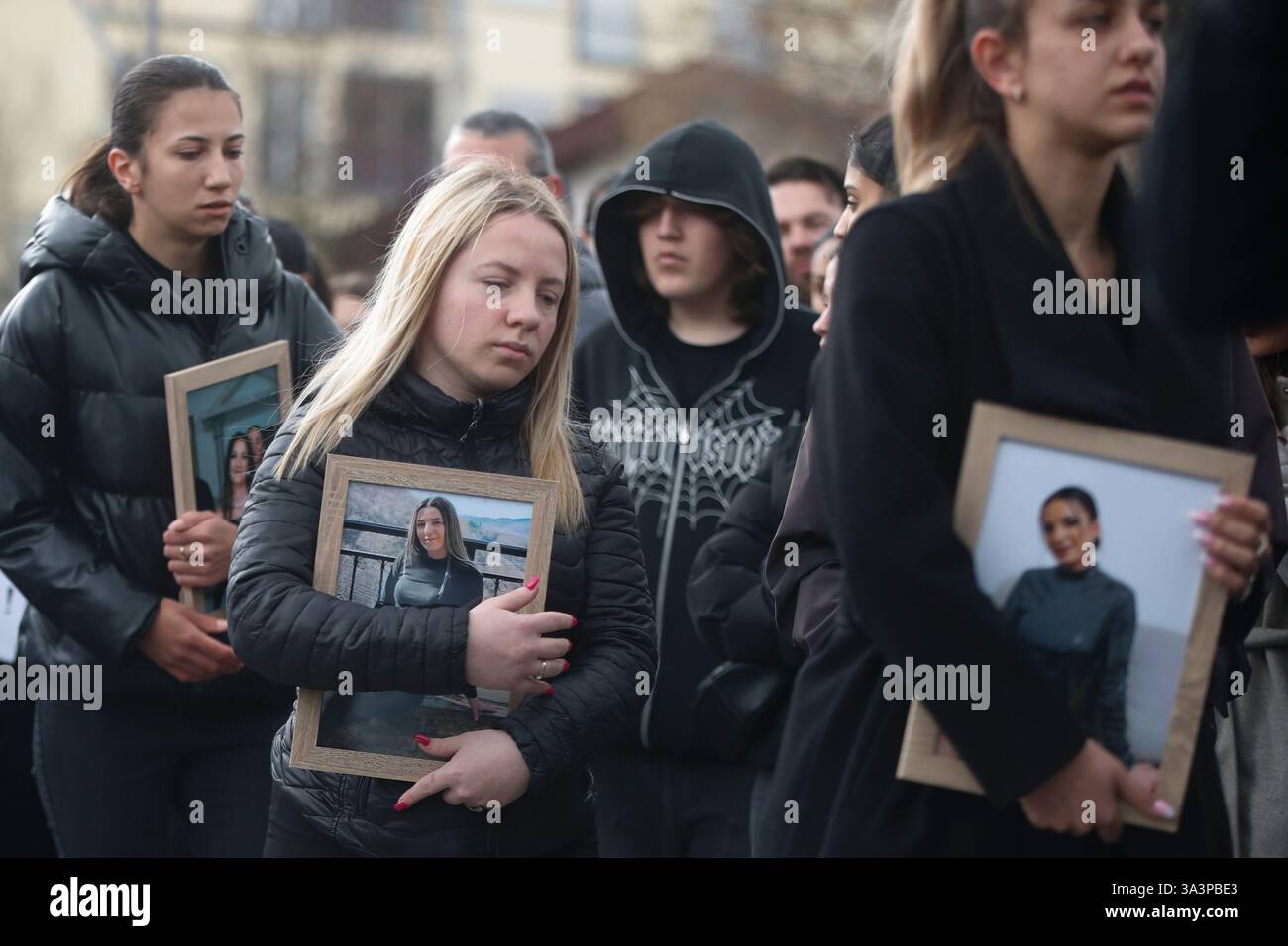 People hold photos of the victims of a massive nightclub fire, during a vigil joined by hundreds ...
