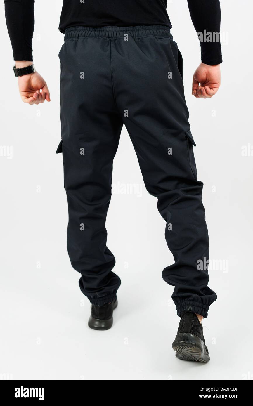 The back view of a man who is dressed in stylish black cargo pants ...