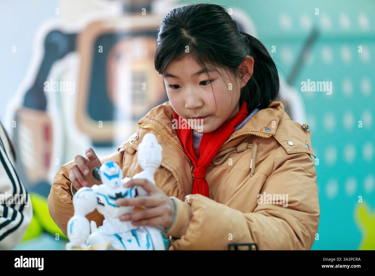 TENGZHOU, CHINA - MARCH 17, 2025 - A primary school student assembles a ...