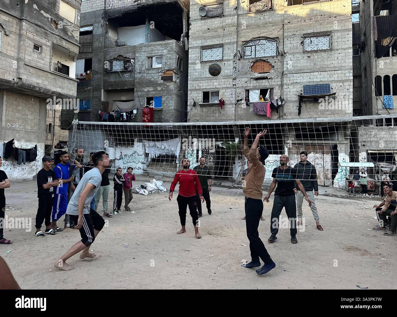 Palestinians play volleyball amid the rubble of destroyed buildings in ...