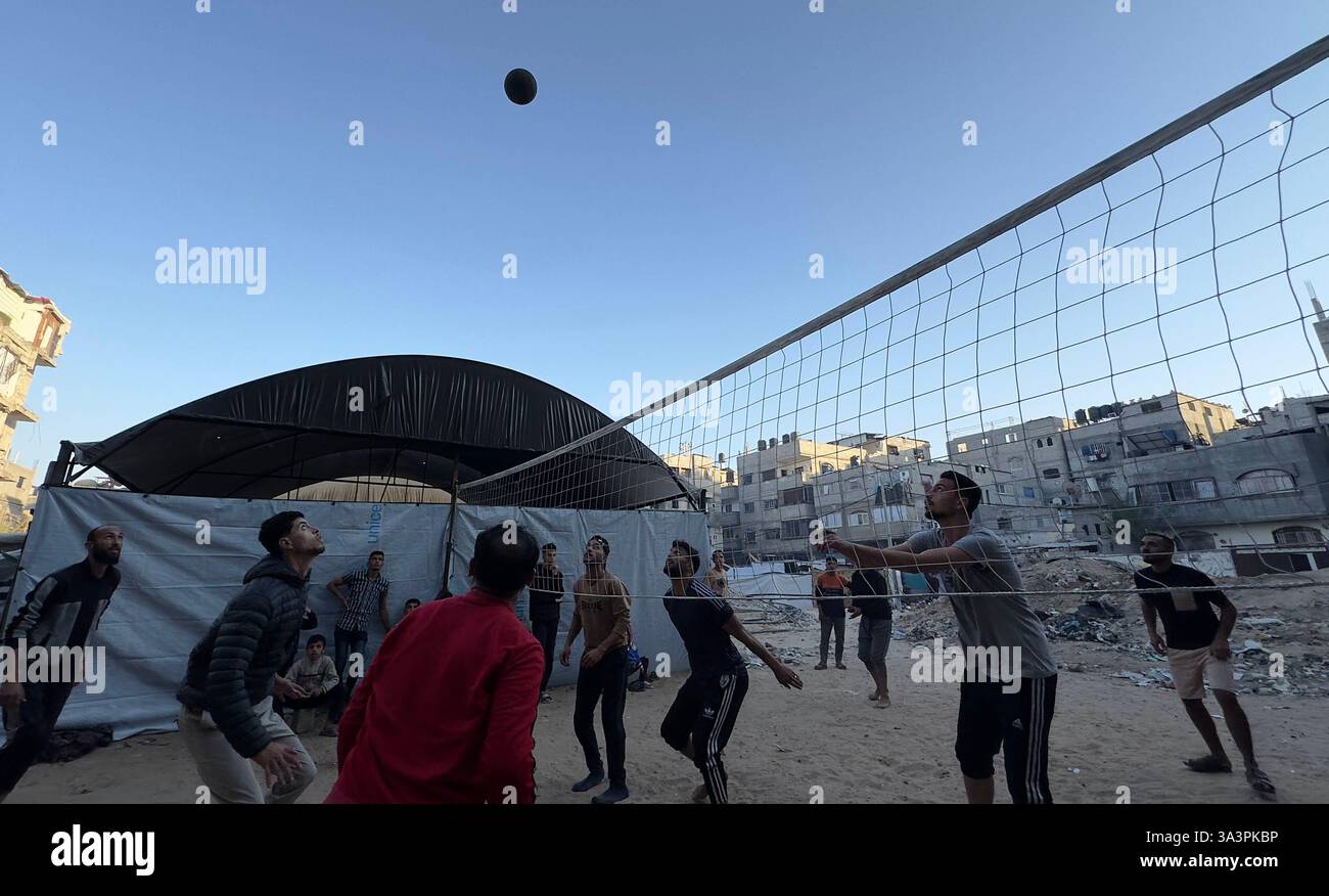 Palestinians play volleyball amid the rubble of destroyed buildings in ...