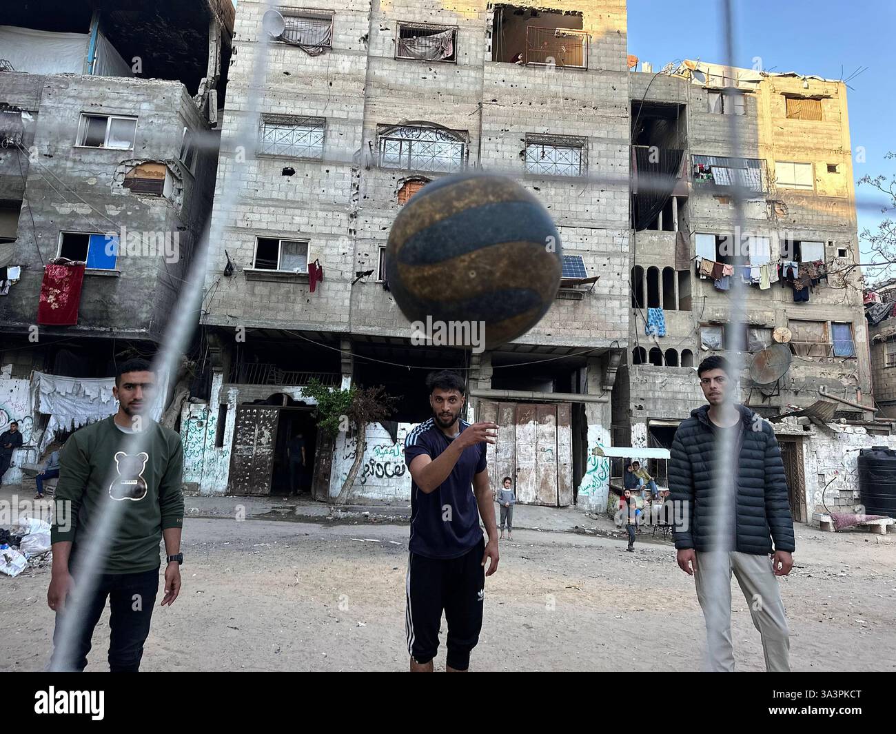 Palestinians play volleyball amid the rubble of destroyed buildings in ...