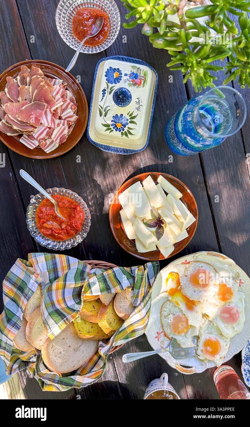 A traditional Balkan breakfast spread with dried meat, cheese, ajvar ...