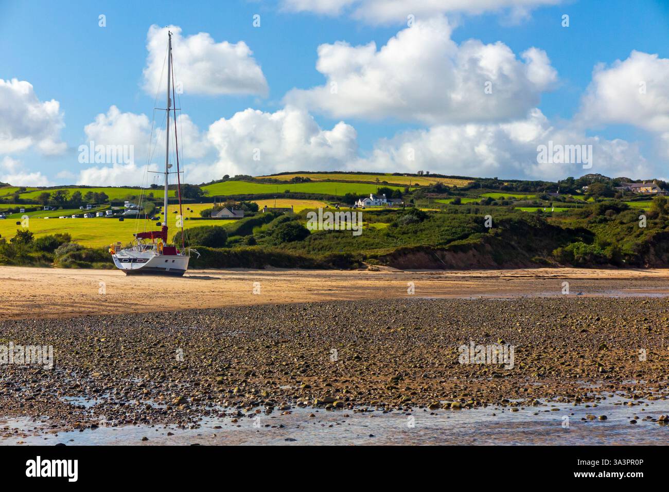 The sandy beach at low tide at Traeth Lligwy near Moelfre on the north ...