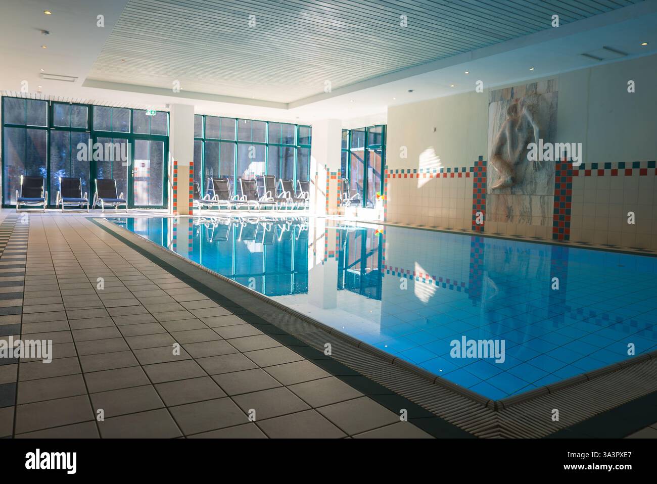 Indoor Swimming Pool with Lounge Chairs and Large Glass Windows Stock ...
