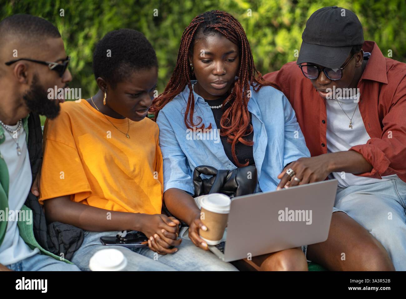 African American multiracial students researching on laptop, discuss project, digital nomad in ...
