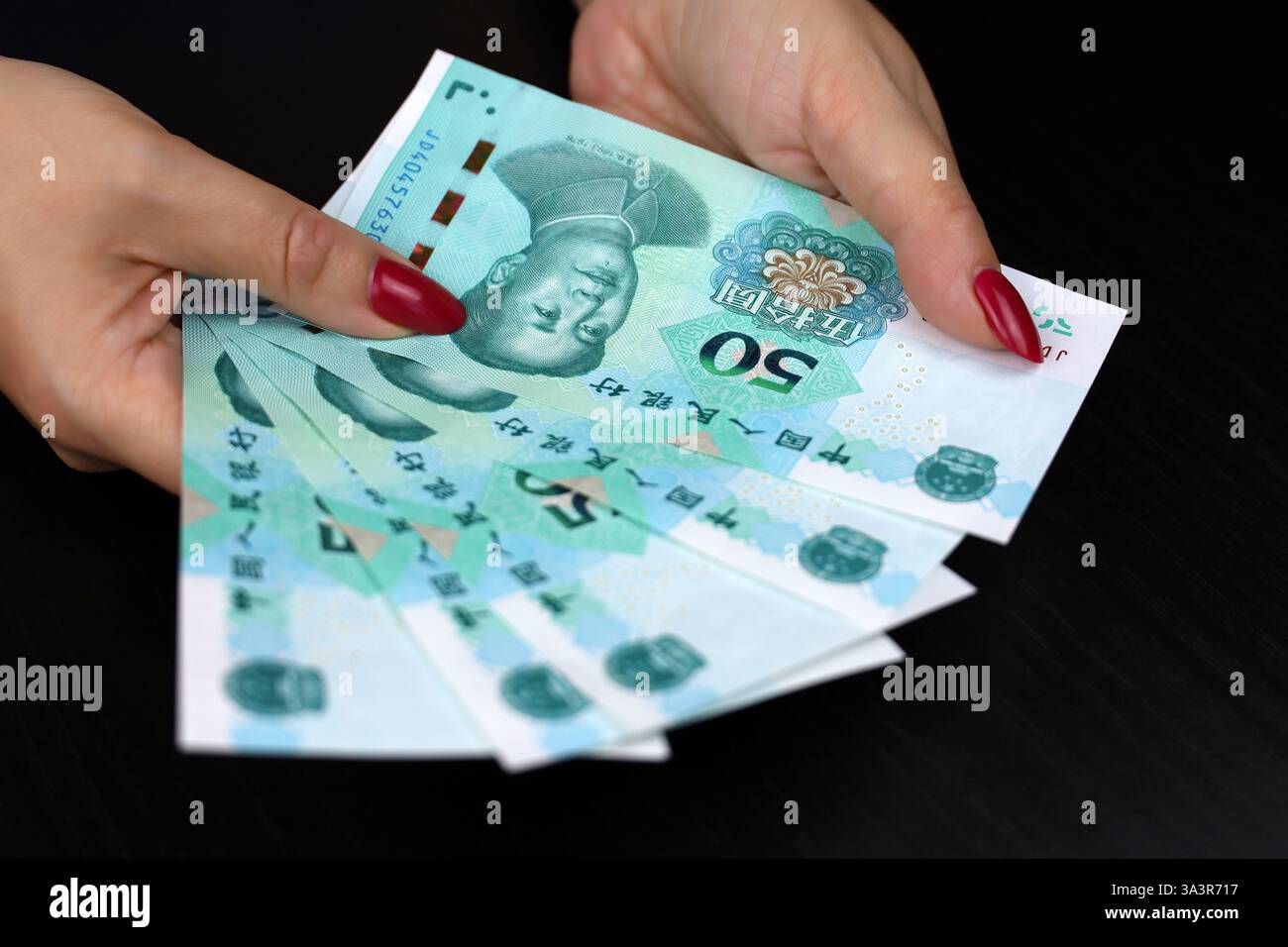 Chinese yuan banknotes in female hands. Salary, bonus, concept of ...