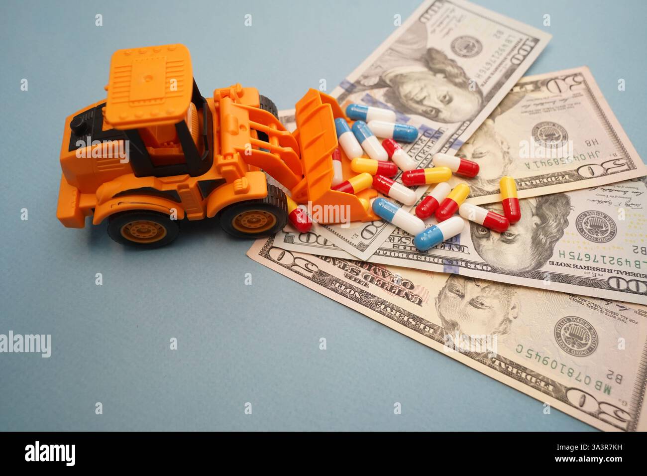 banknotes and an excavator loading a handful of capsule tablets ...
