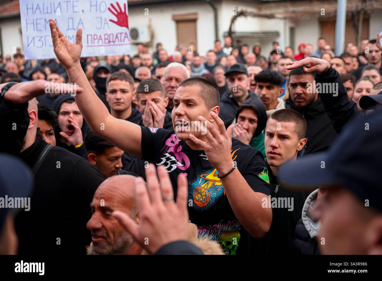 People argue with policemen, outside the home of the owner of a ...