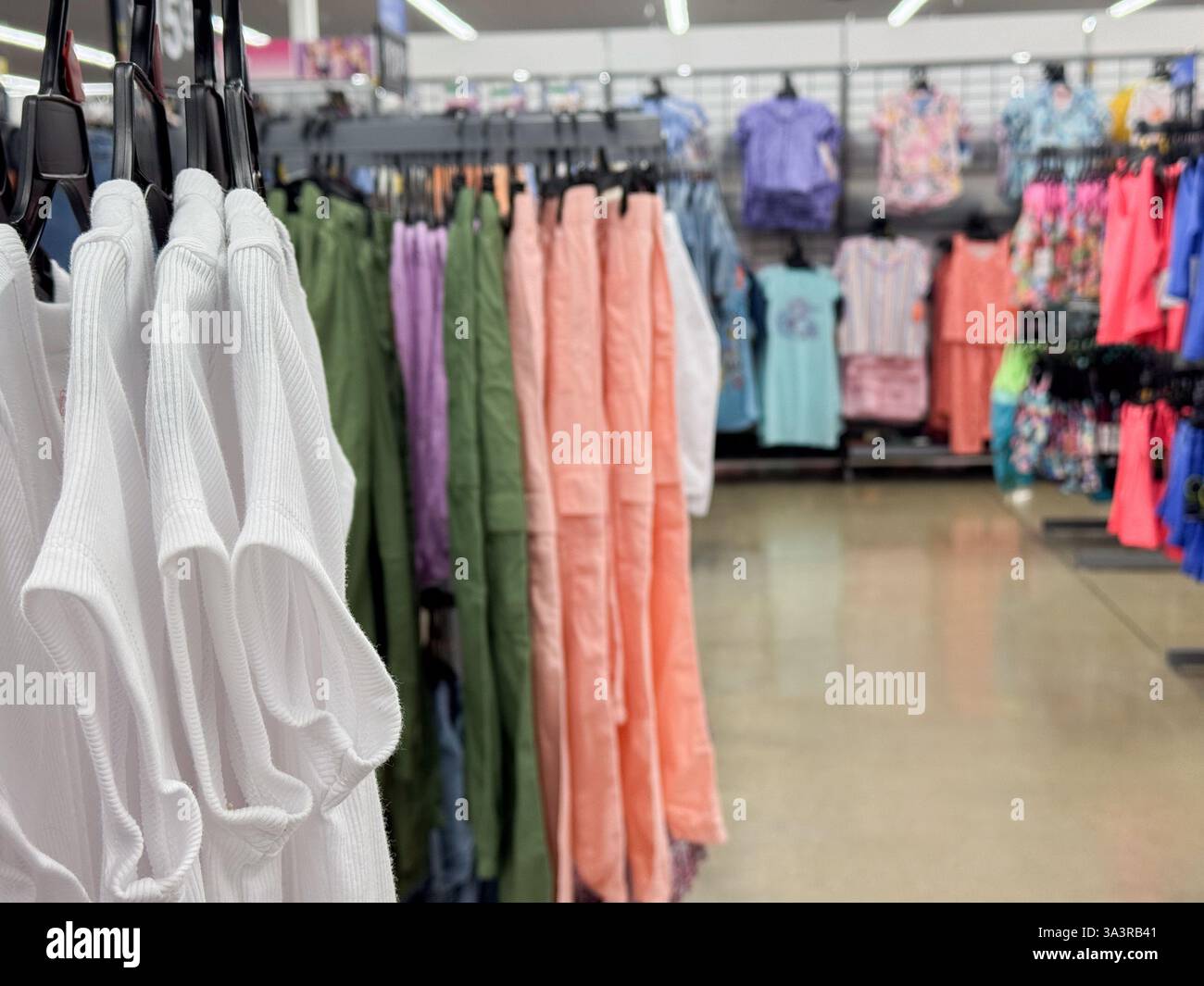 a clothing store interior with neatly arranged racks displaying a ...