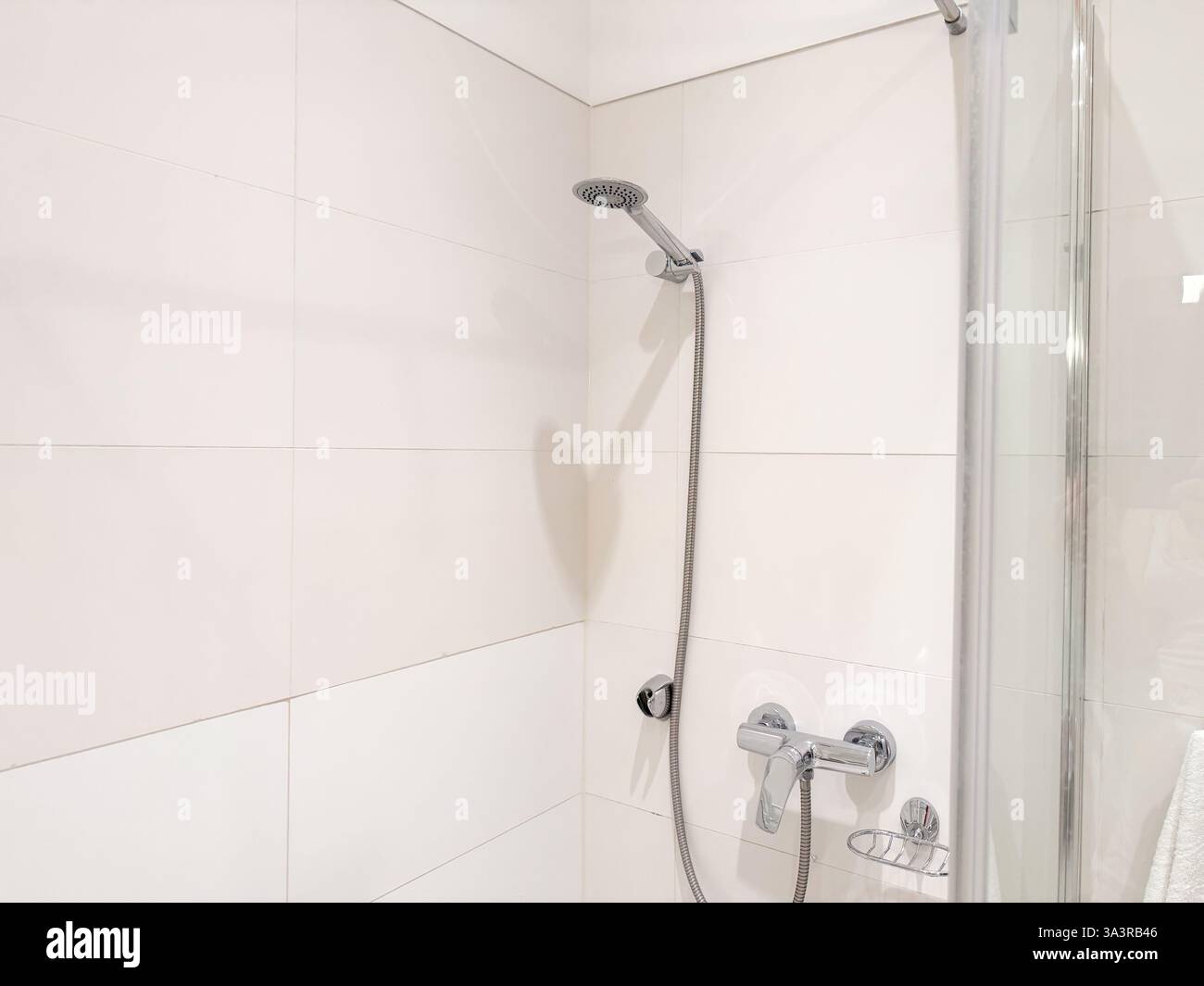 a modern bathroom shower area with a sleek chrome showerhead attached ...