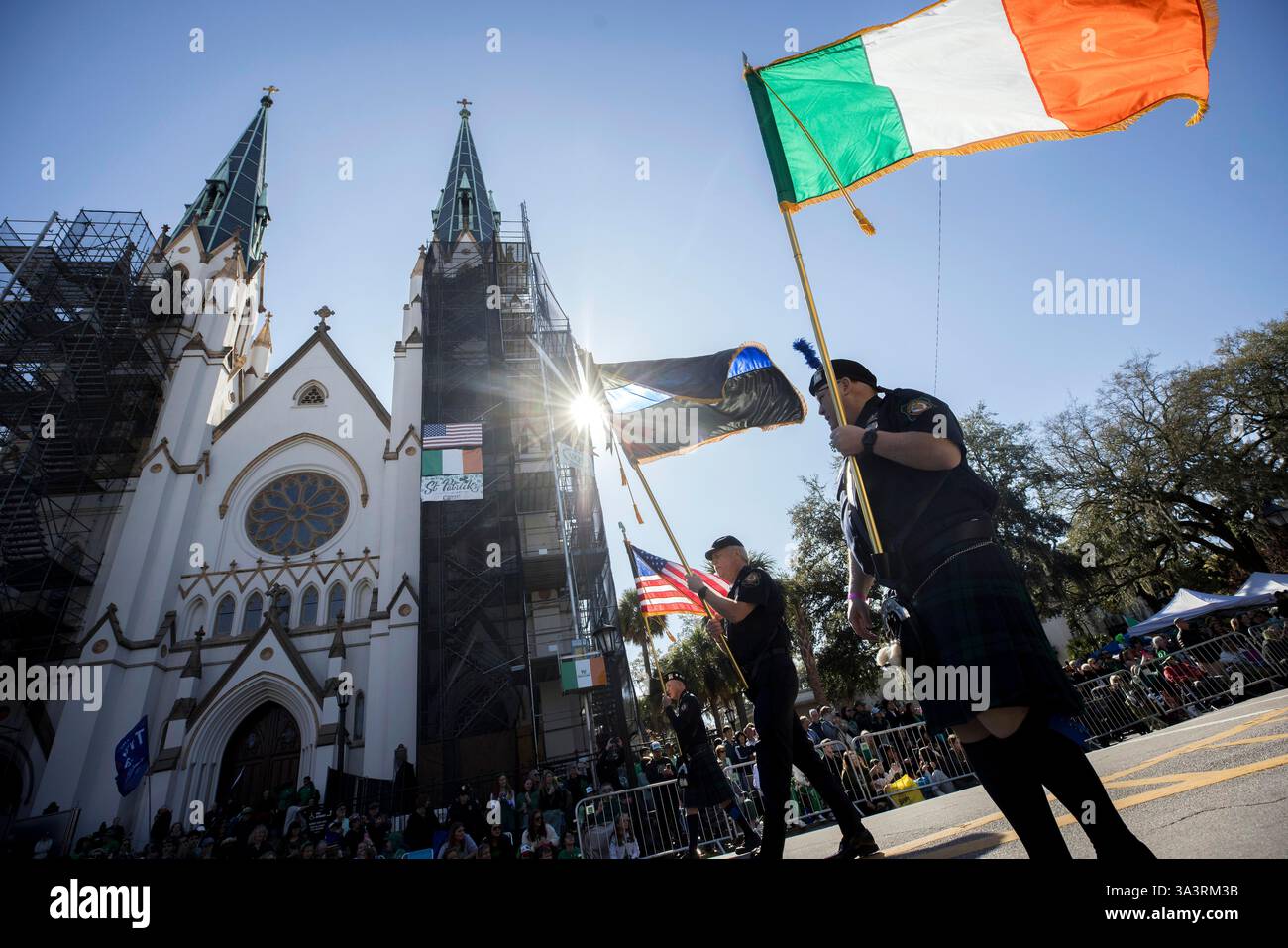 Paddy Withers, right, carries the Irish flag while marching with the ...