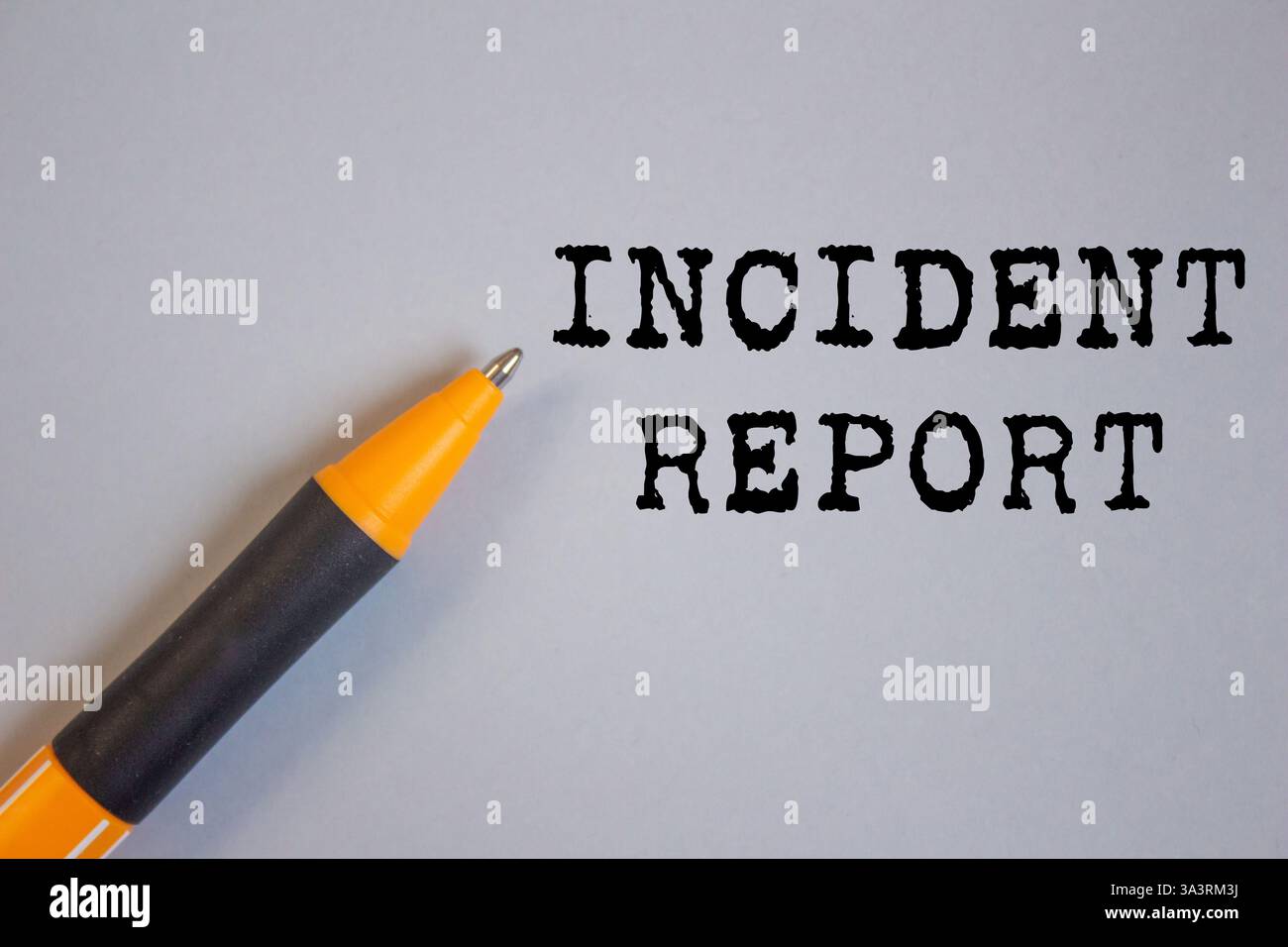 Incident report message written on gray background with a pen ...