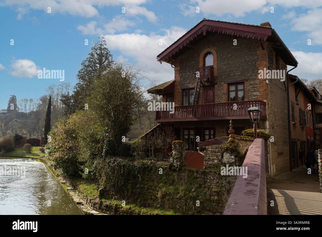 A riverside stone and brick house just across the pedestrian bridge ...