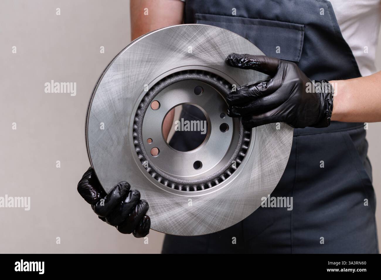 Auto mechanic holds new brake disc in hands, close-up. Auto parts ...