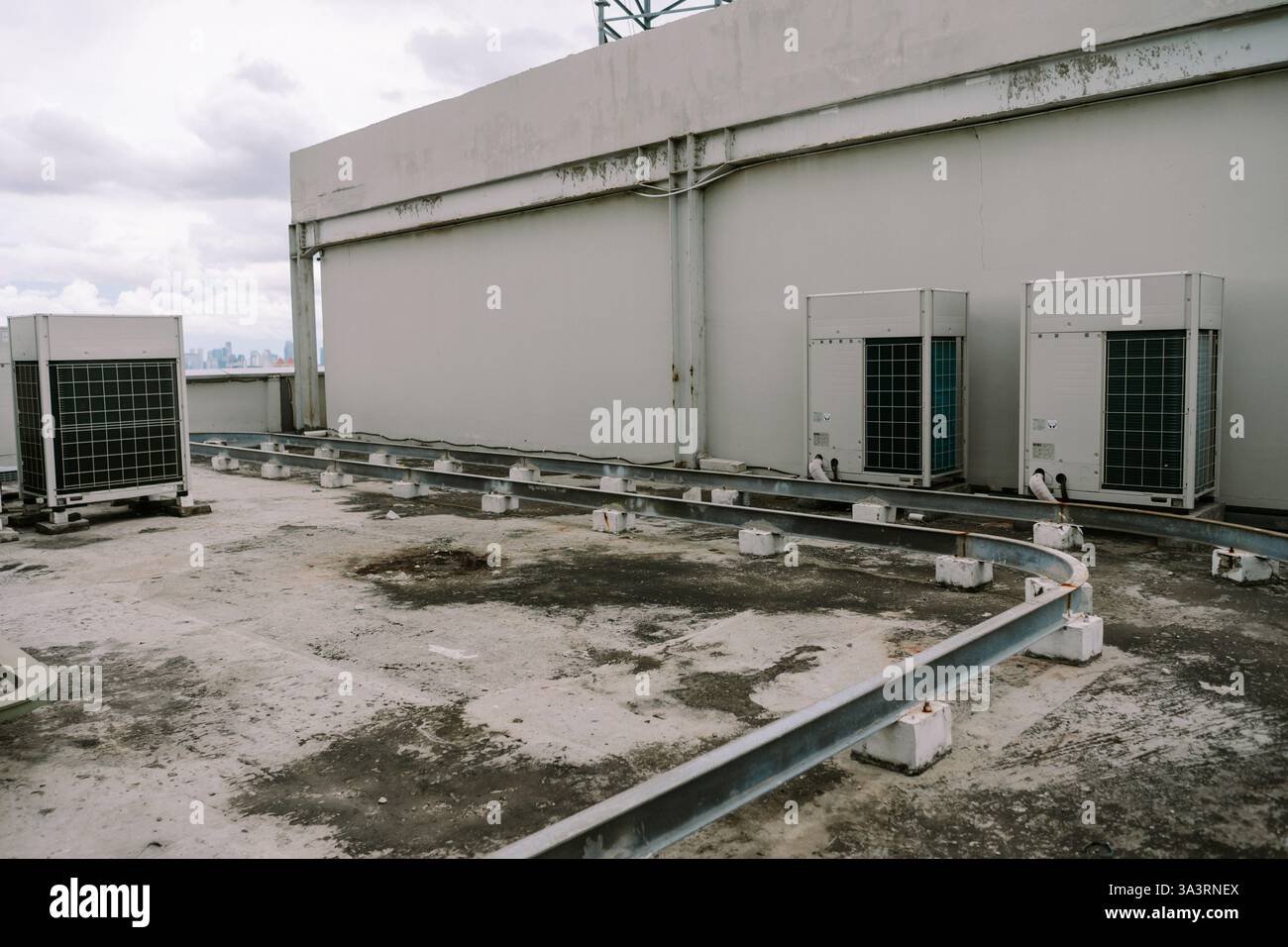 Three air conditioning units sit atop a commercial rooftop with ...