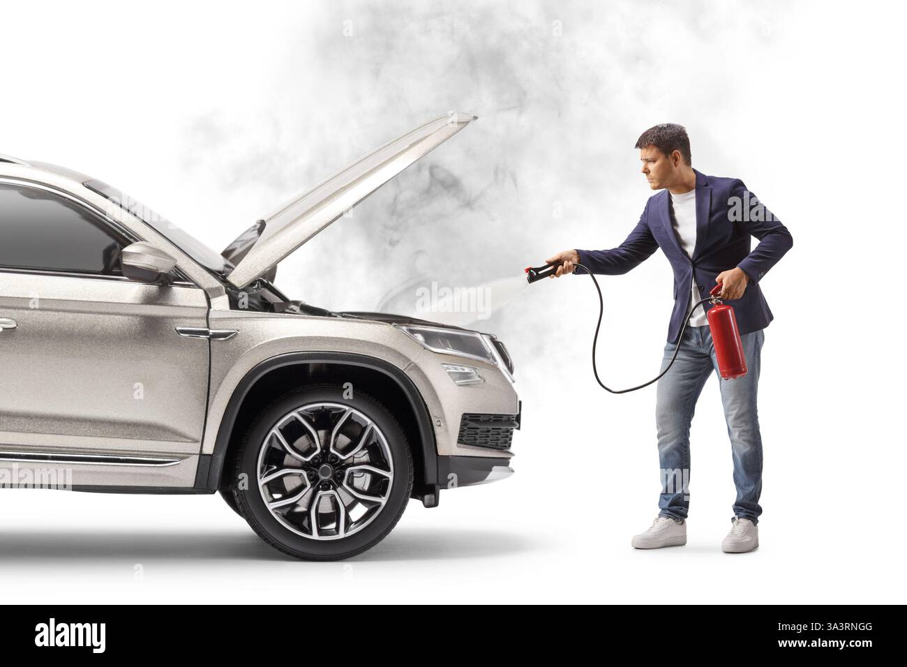 Man spraying a car fire extinguisher for a vehicle with an open hood ...