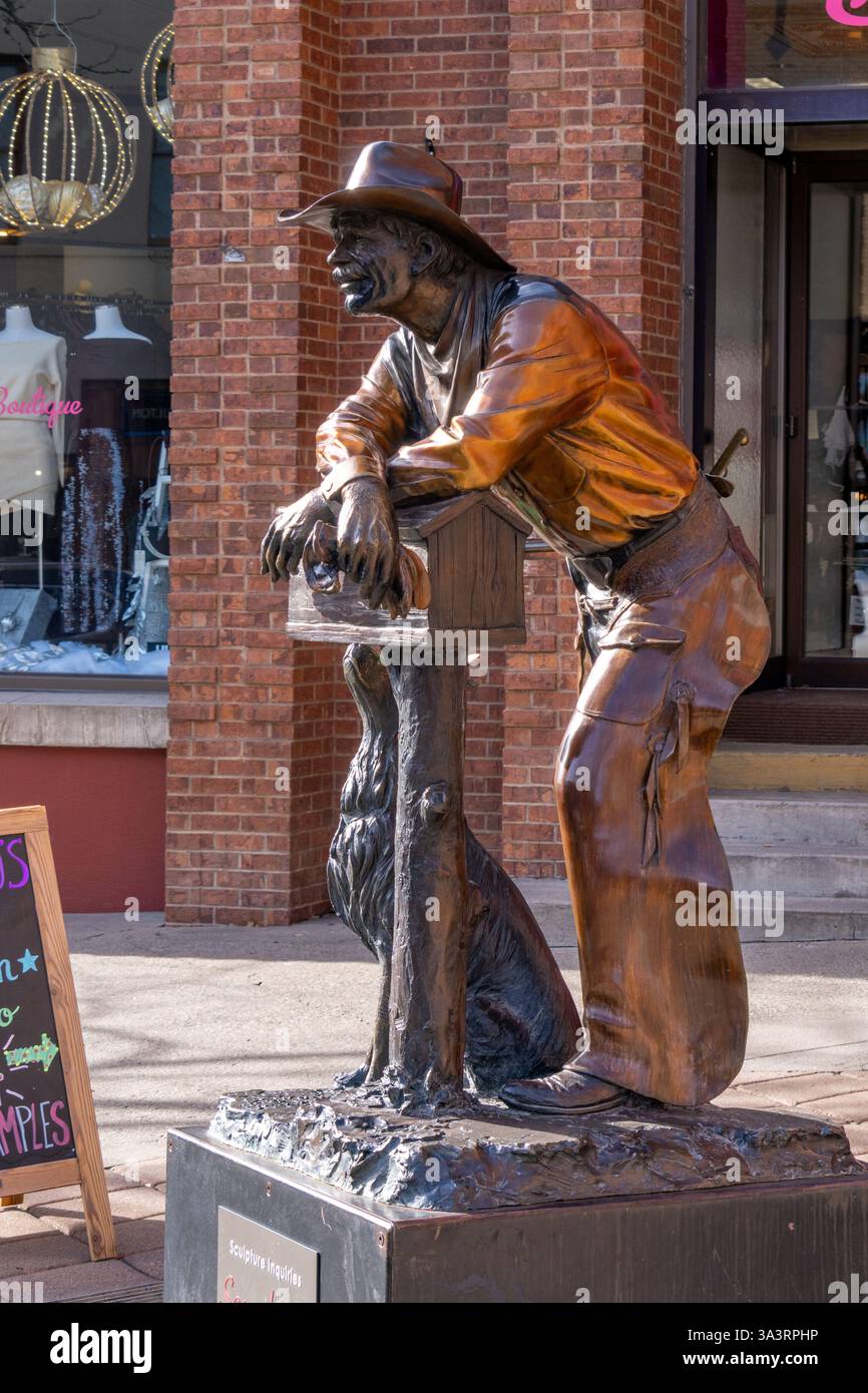 A bronze statue of a cowboy and his dog on Main Street in the historic ...
