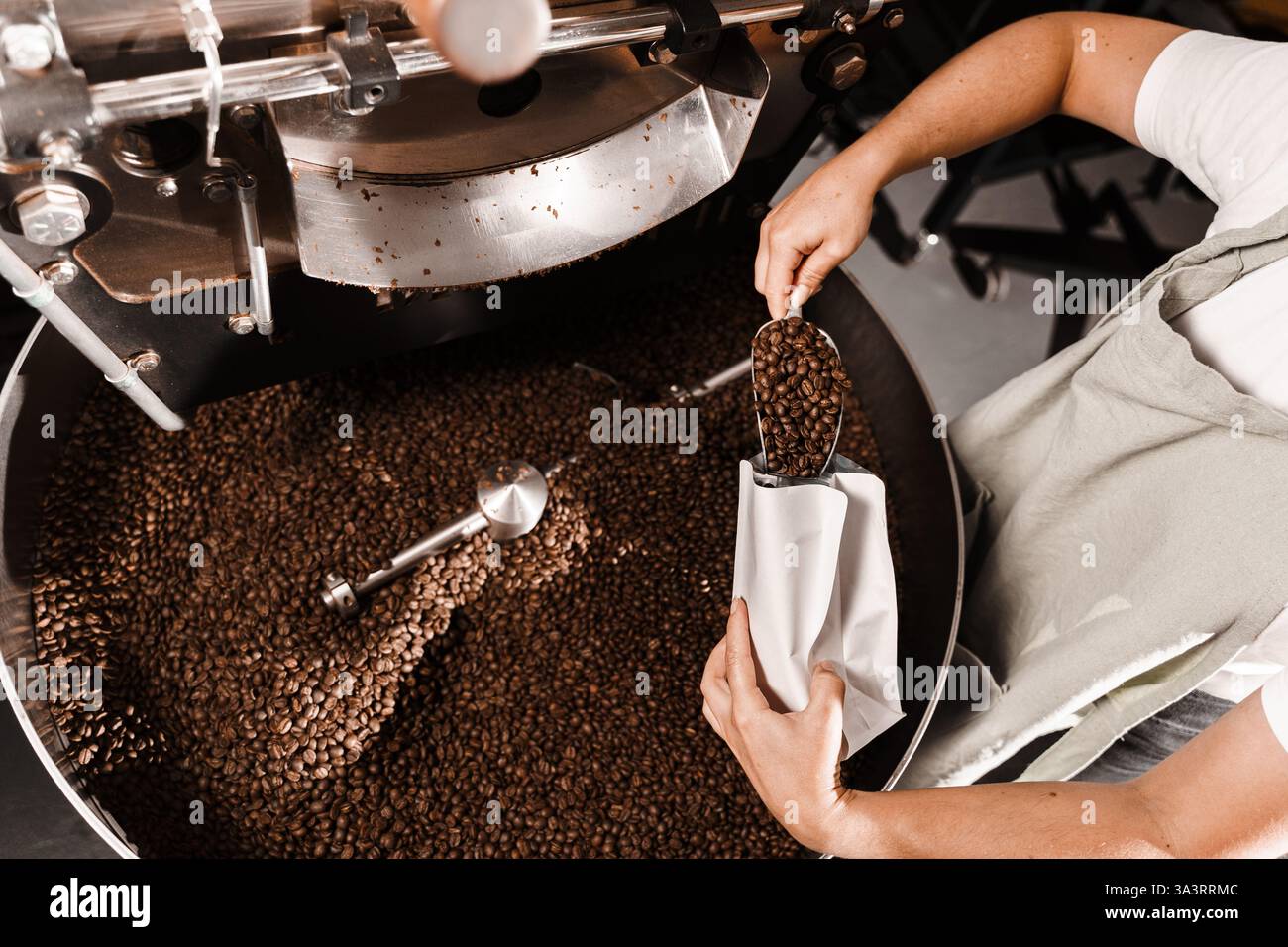 Packing roasted coffee beans into a craft bag. Pouring fried coffee ...