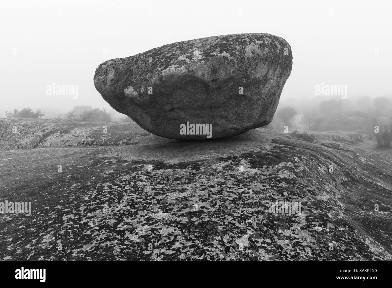 Balancing rock formation in foggy landscape Stock Photo - Alamy