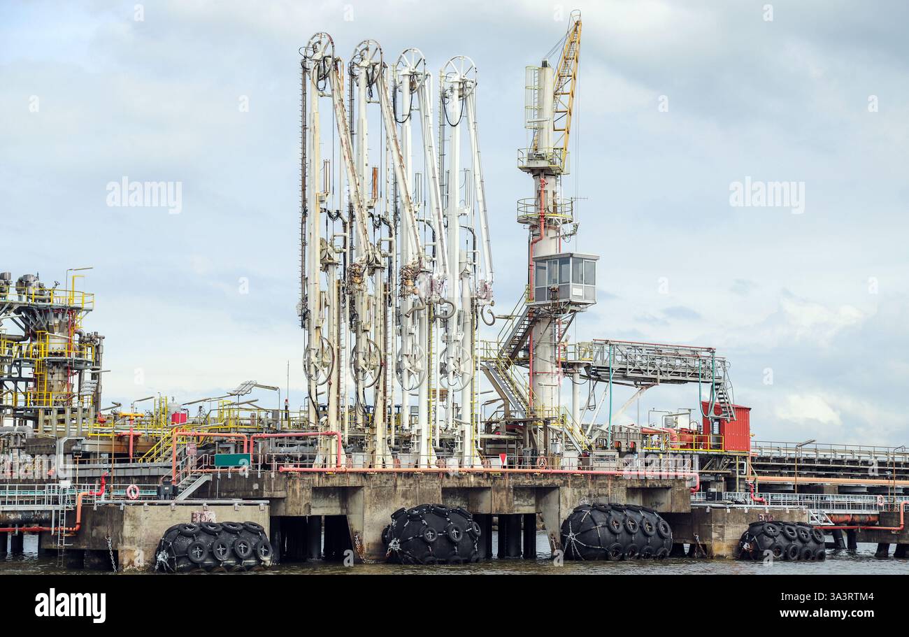 View of an industrial oil terminal with large loading arms and marine ...