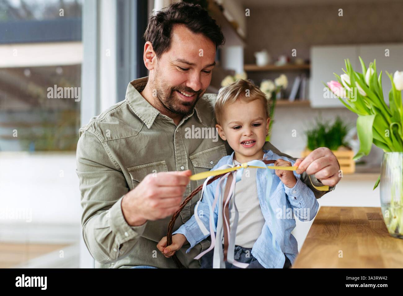 Father and little boy braiding easter whip from willow branches. Easter ...