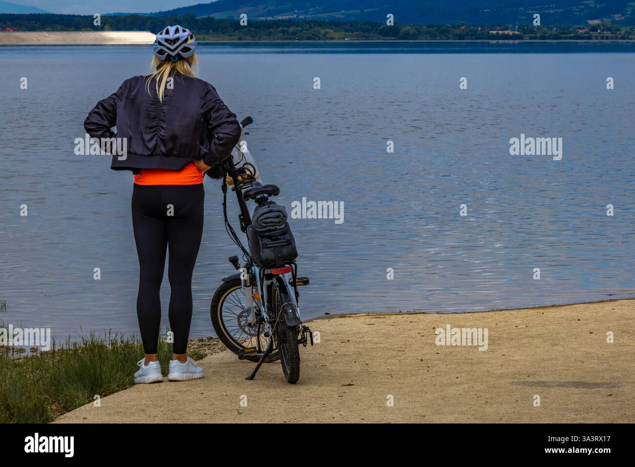 A woman in tight black leggings with a shapely figure admires the ...