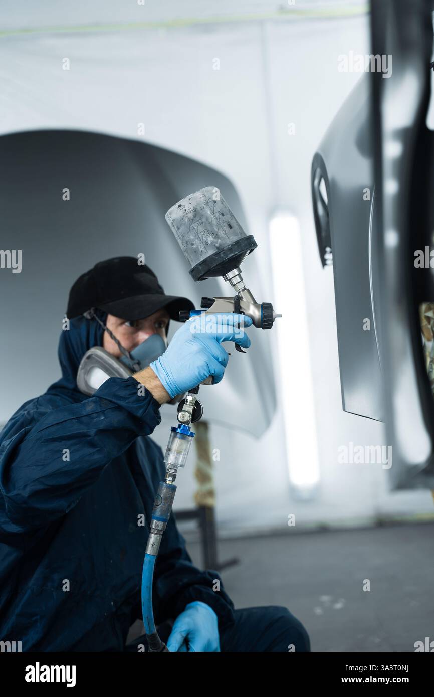 Car painter is changing the color of vehicle using sponge and paint ...