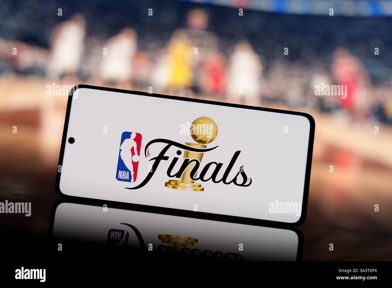 Smartphone displaying NBA Finals logo with a blurred basketball court ...