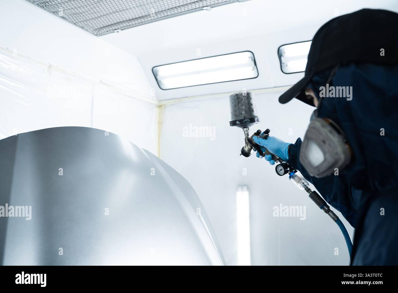 Car painter is painting automobile. Mechanic from vehicle maintenance ...