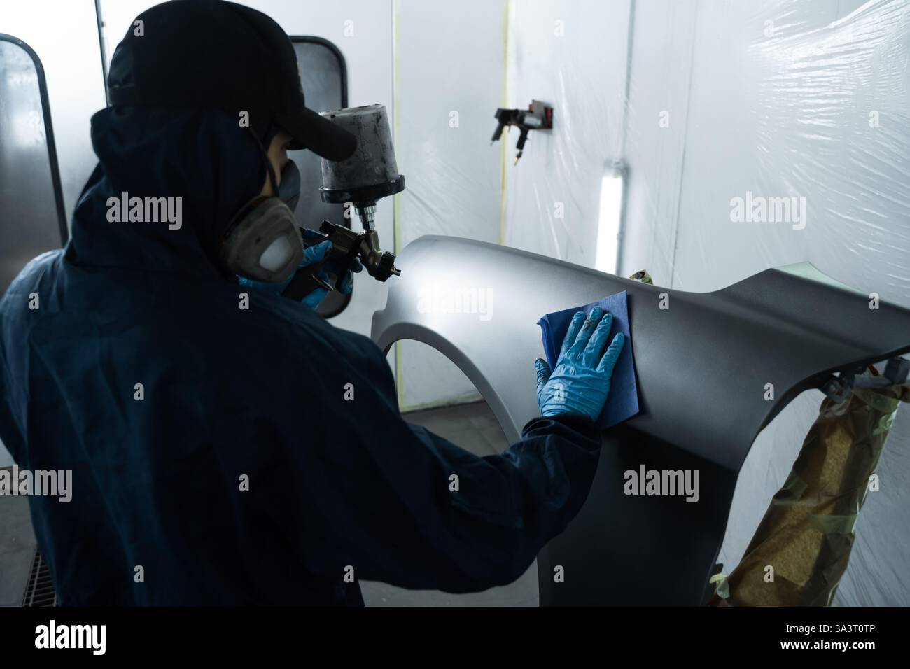 Car painter is changing the color of vehicle using sponge and paint ...