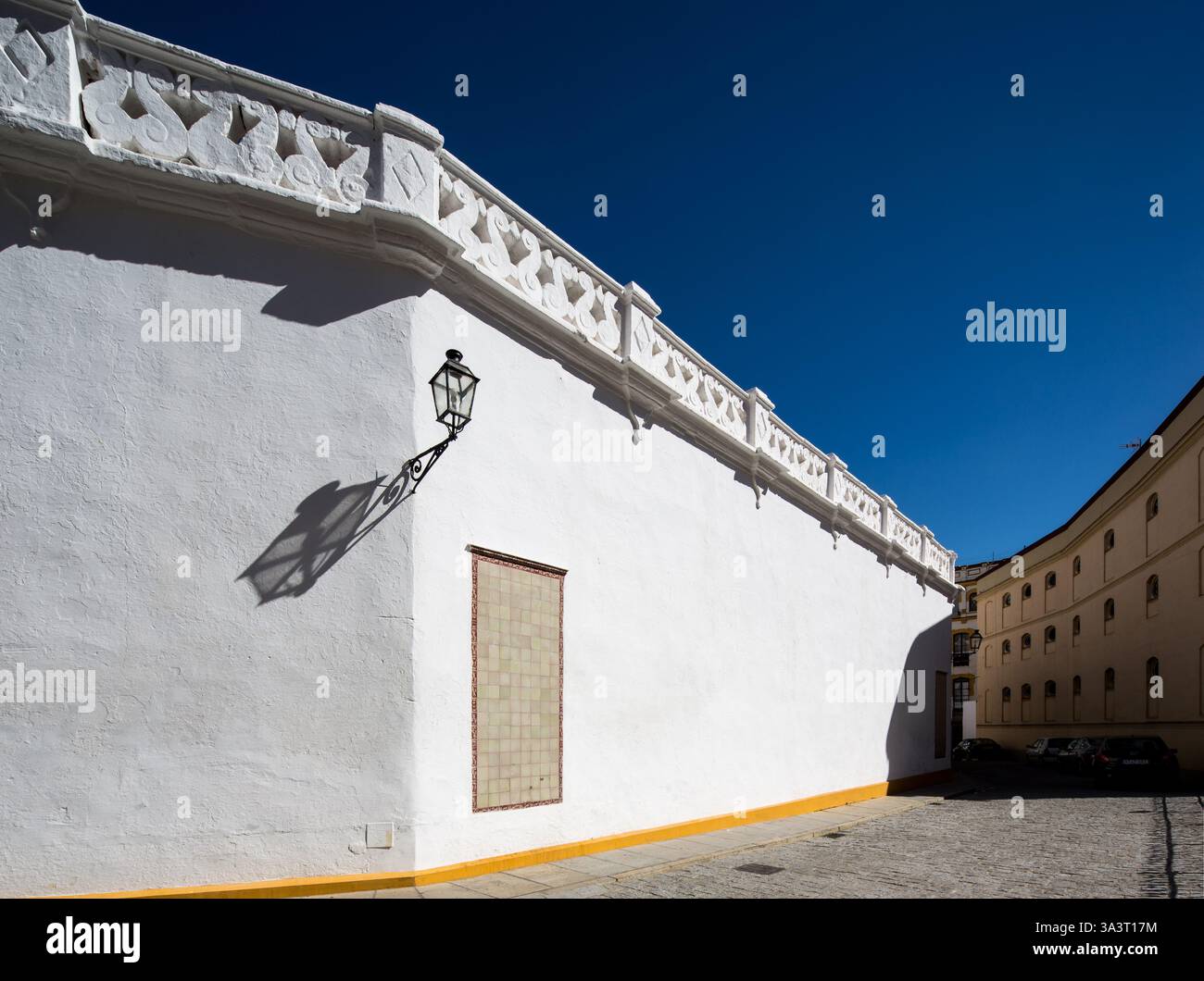 Visitors admire the striking white wall of the bullring in Seville ...