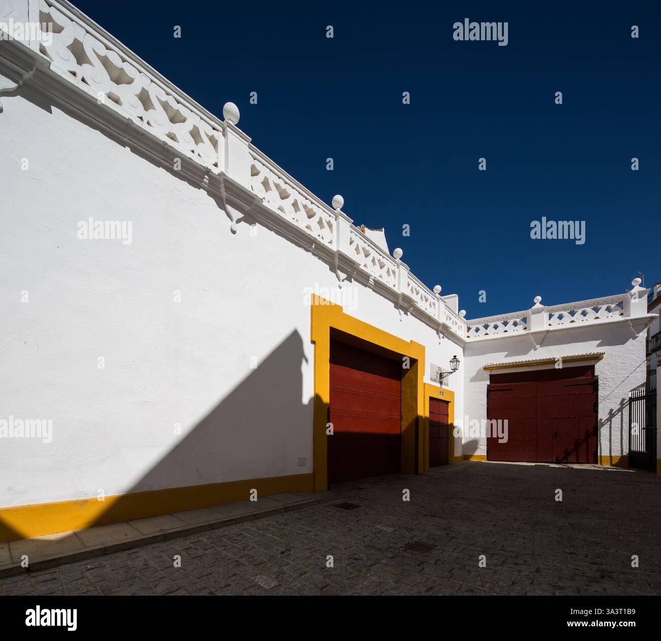Visitors admire the striking white wall of the bullring in Seville ...