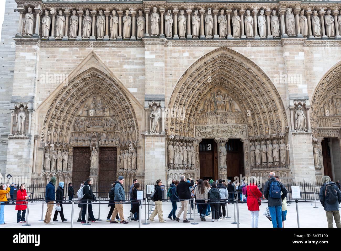 People waiting in the queue to enter the famous Notre Dame de Paris in ...