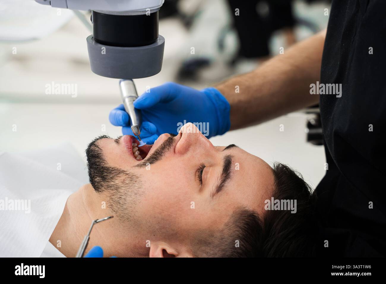 Dentist uses dental polisher hardware and mirror to whiten teeth of the ...
