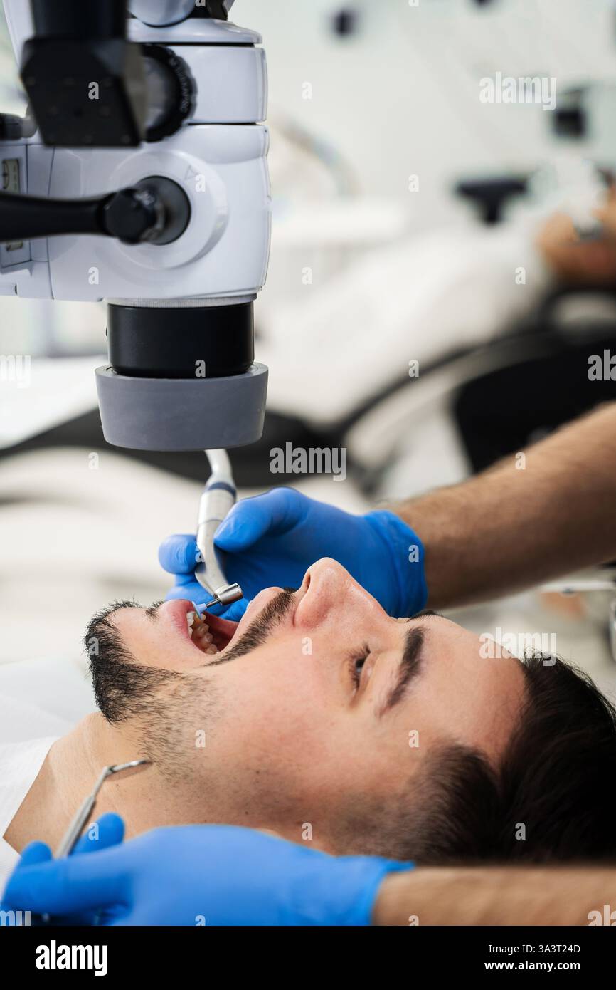 Polishing teeth under a digital microscope process. Dentist uses dental ...