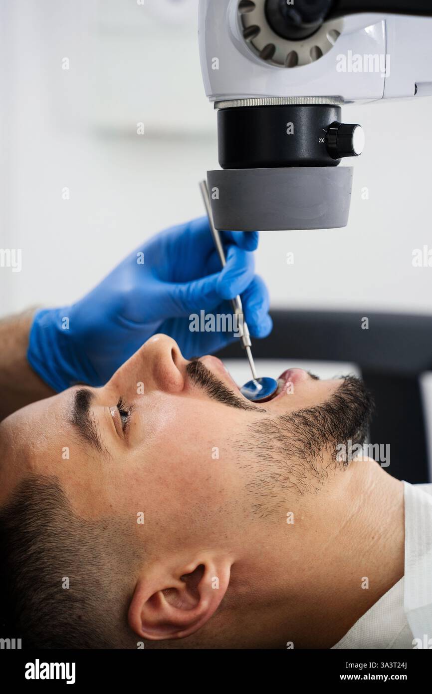 Dentist uses operating microscope to polish teeth of the patient ...