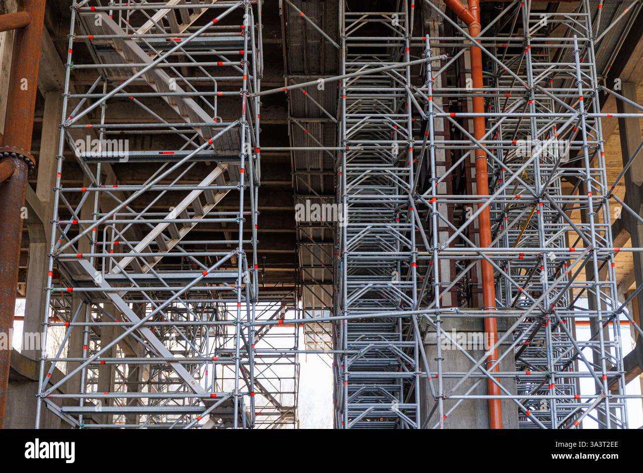 Metal scaffolding structure under a bridge construction site. Industrial framework and ...