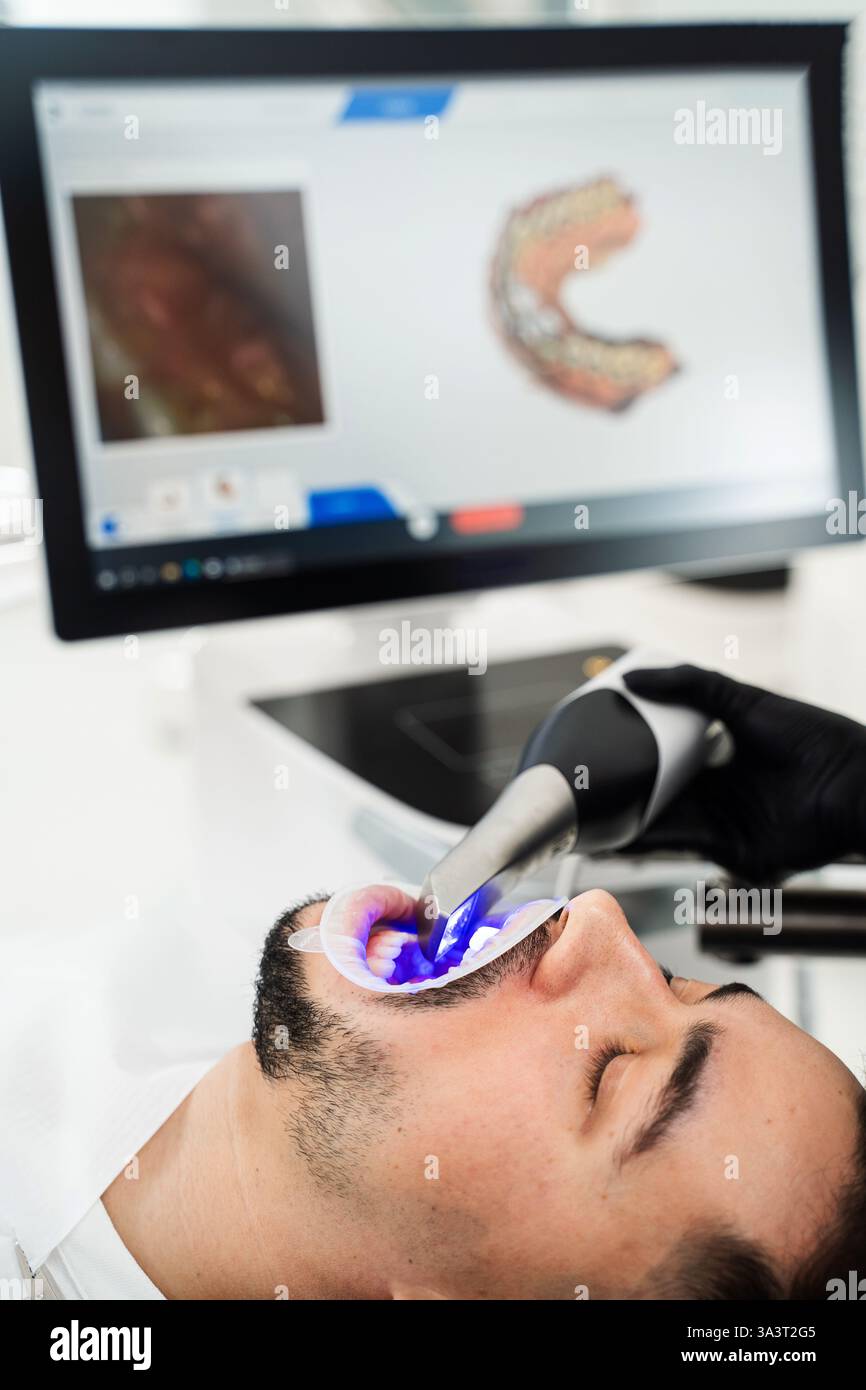 Doctor examines teeth of patient with x-ray scanning equipment. Dental ...