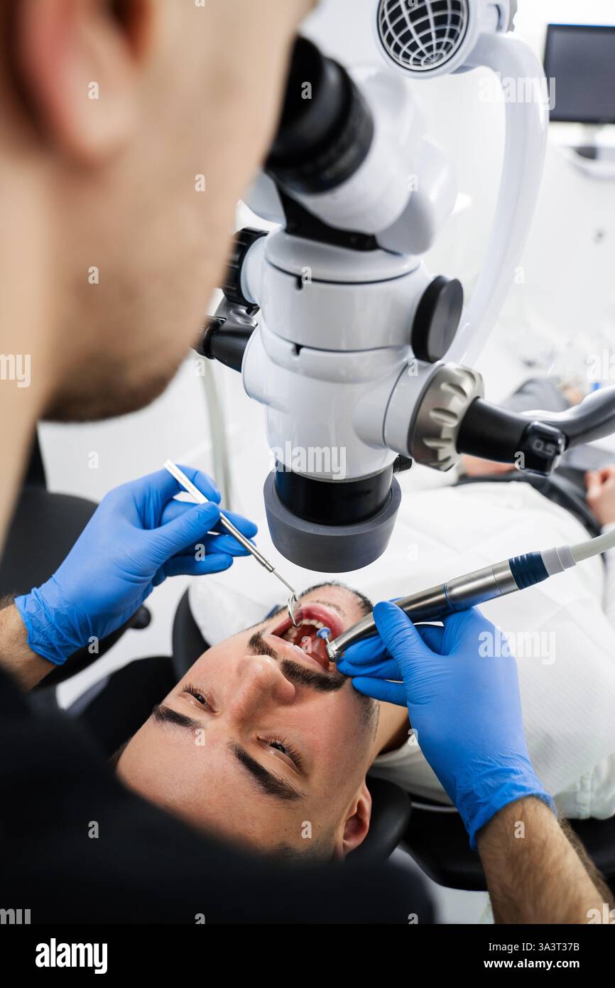 Dentist uses operating microscope to polish teeth of the patient ...