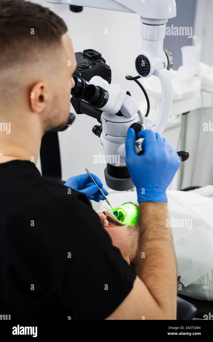 Surgical microscope examination procedure. Dentist is looking on teeth ...