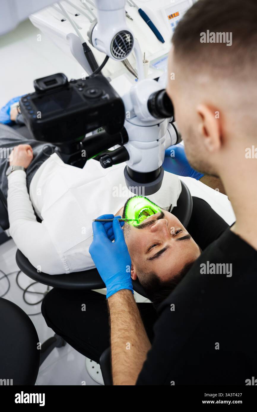 Dentist is looking on teeth condition by surgical digital microscope in ...